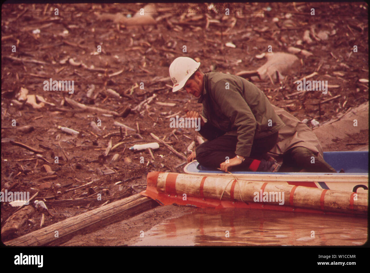 EPA MAN CHECKS LOG BOOM FOR LEAKAGE OF OIL AND DEBRIS FOLLOWING A ...
