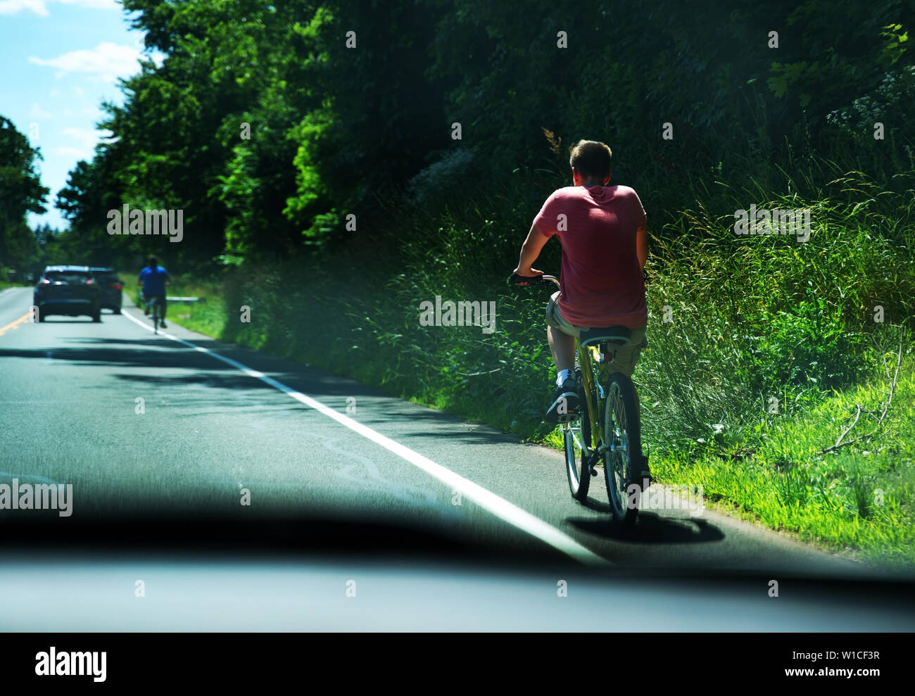 A driver`s view of young men on bicycles utilizing the roads bike lanes ...