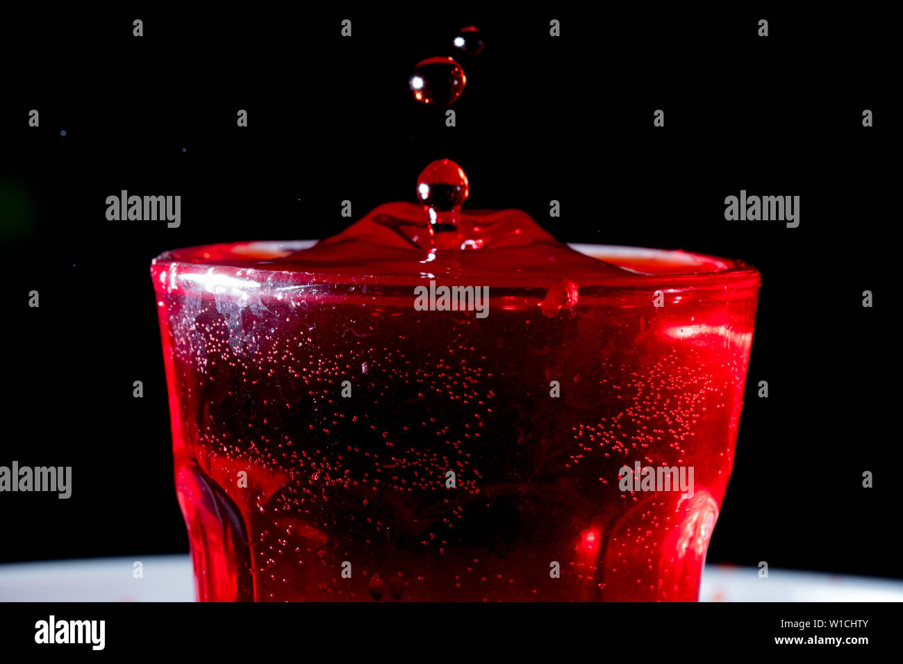 drops of red liquid in glass beaker Stock Photo - Alamy