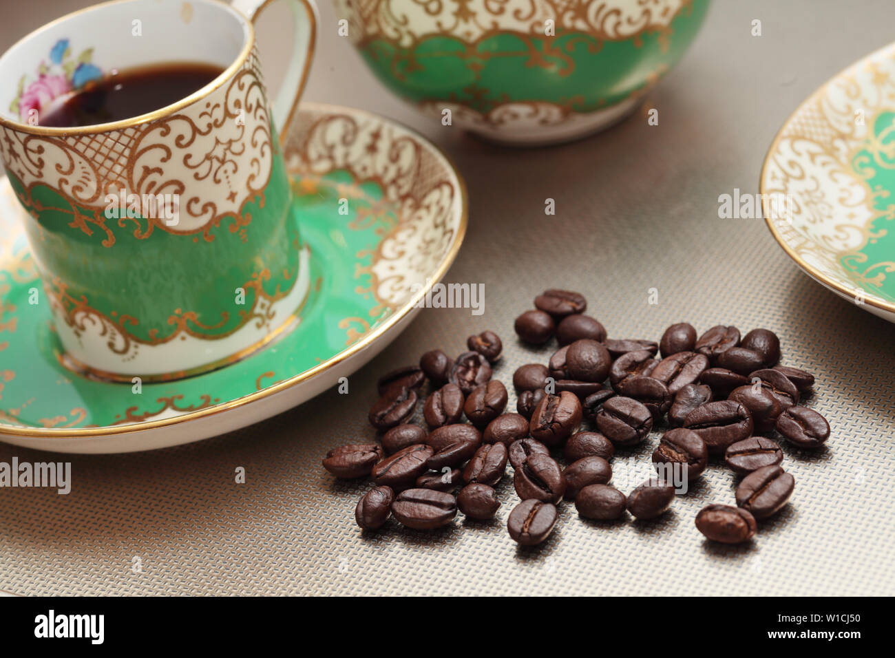 Coffee beans on a table with antique china Stock Photo - Alamy