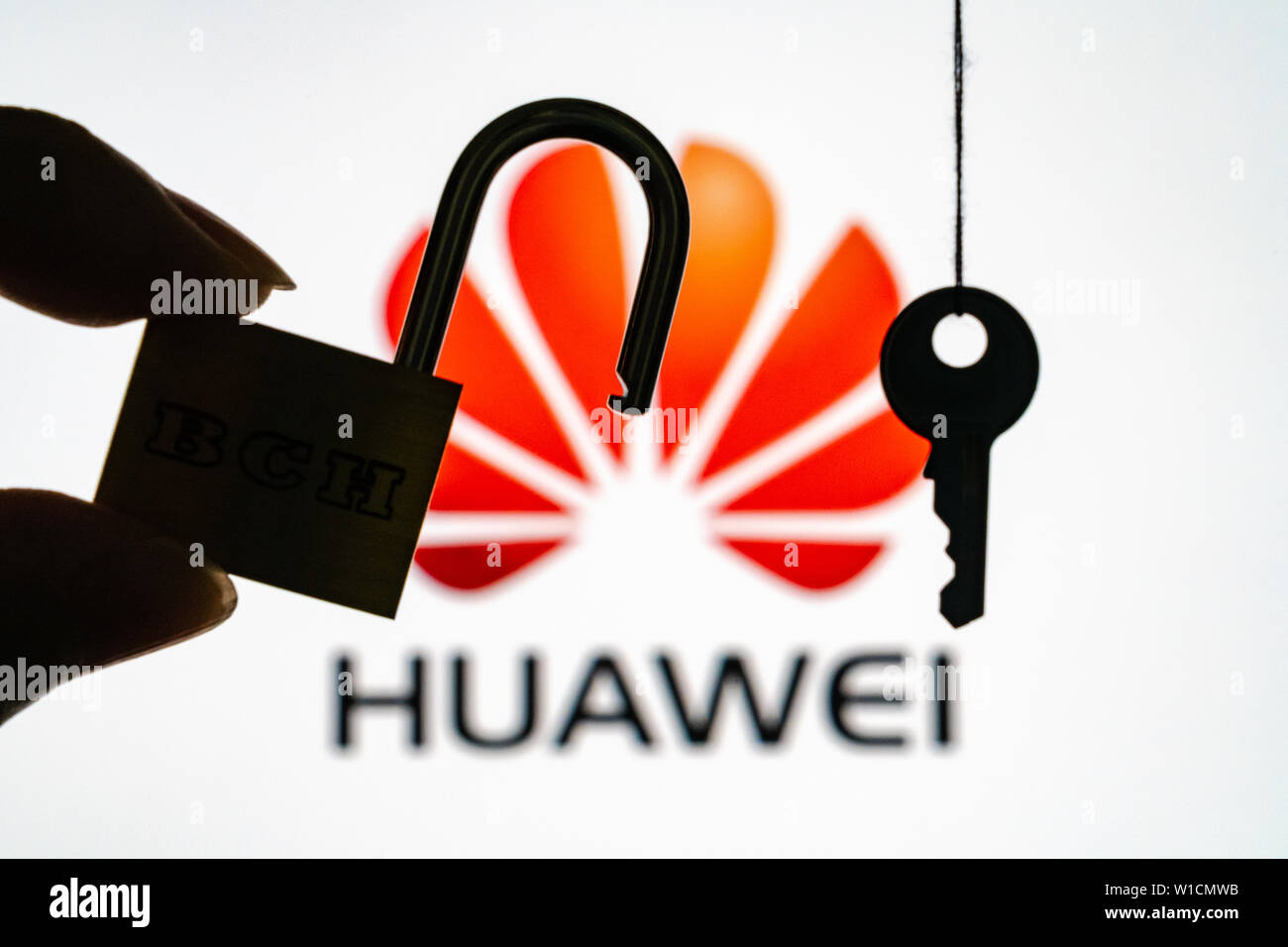 Huawei logo in background with silhouette of a unlock padlock and a key ...
