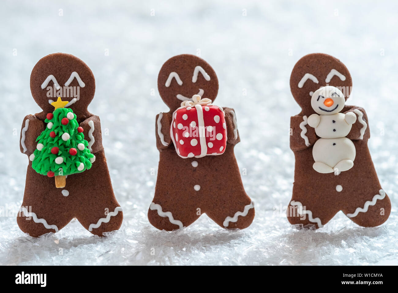 Funny Gingerbread cookie men with tiny marzipan snowman Stock Photo - Alamy