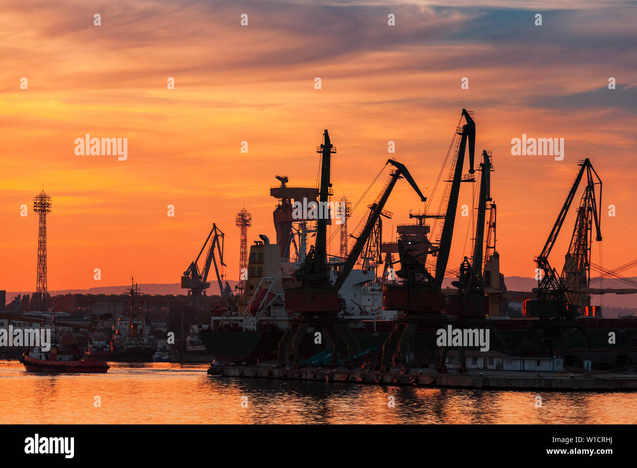 Varna port at sunset under dramatic cloudy sky. Black silhouettes of ...