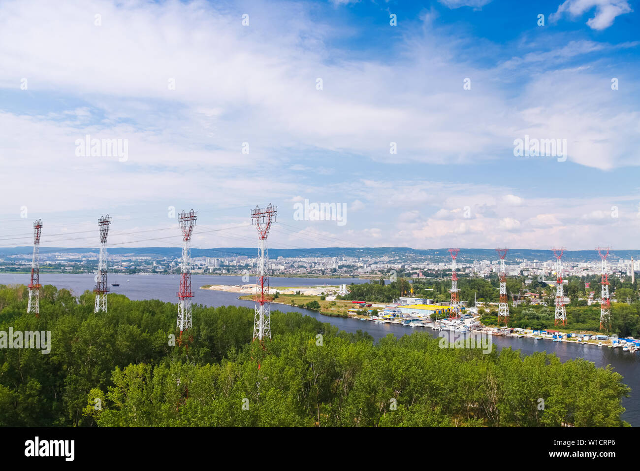 High-voltage power line goes over Varna lake. Red white truss poles ...