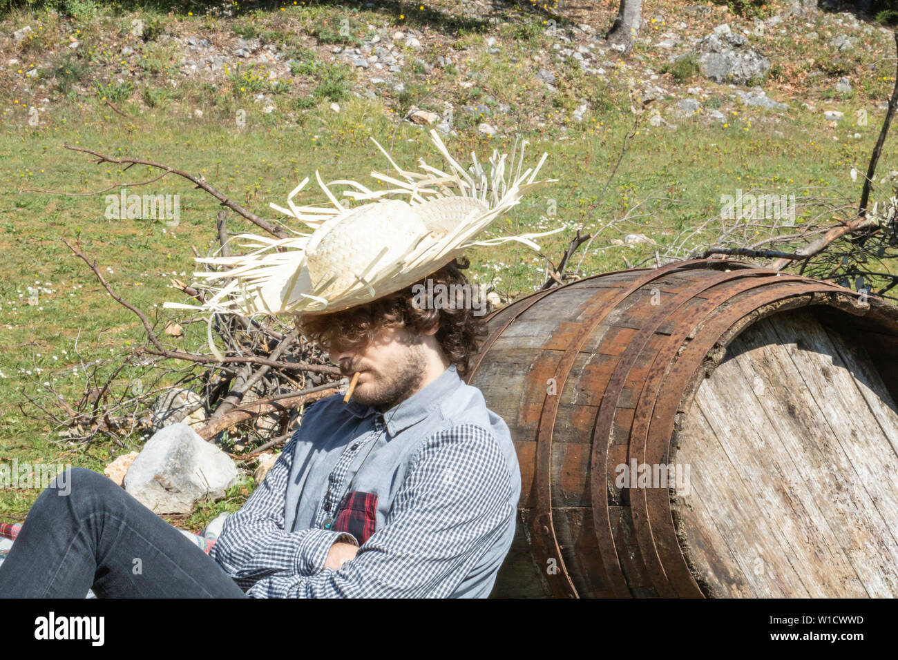 Man taking a nap a hat on his head in the middle of harvest festival ...