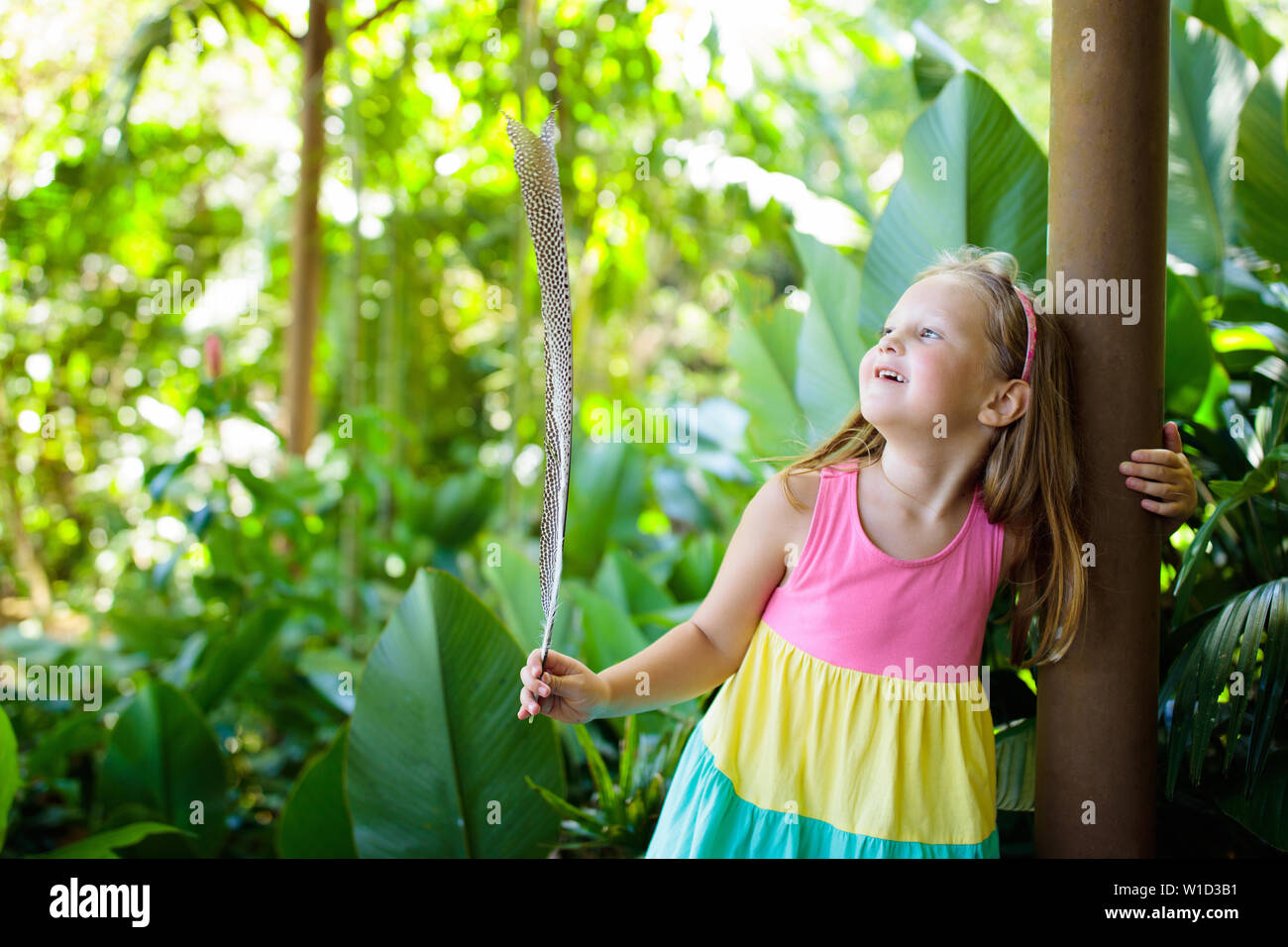 Child playing with big bird feather. Little girl found huge feathers at ...