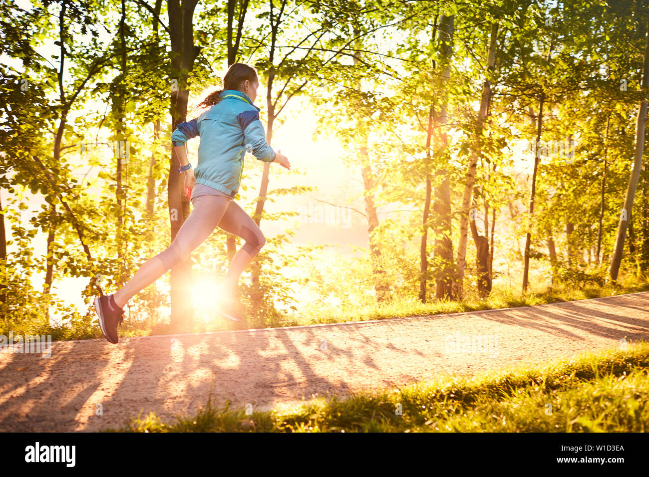 Woman running in sunny morning hi-res stock photography and images - Alamy
