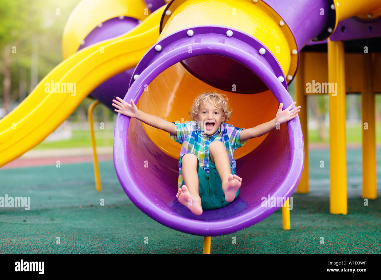 Child playing on outdoor playground. Kids play on school or ...