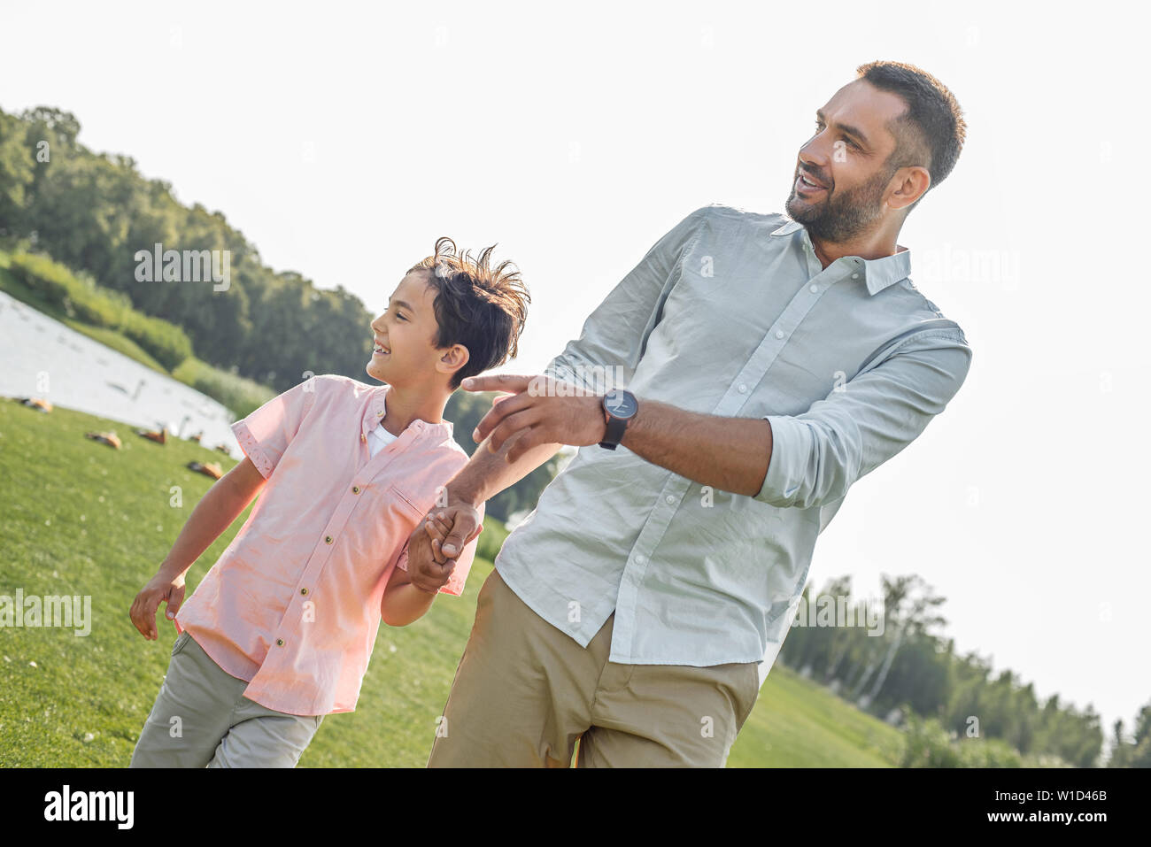 Look over there Happy young father pointing away and smiling while ...