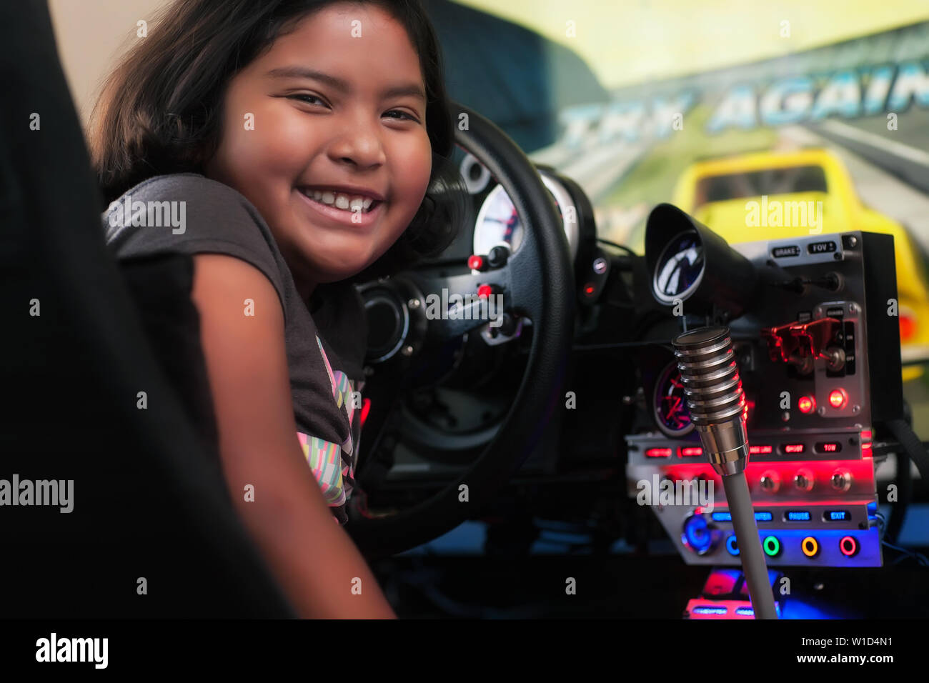 A cute girl with a big smile playing a driving game in a realistic ...