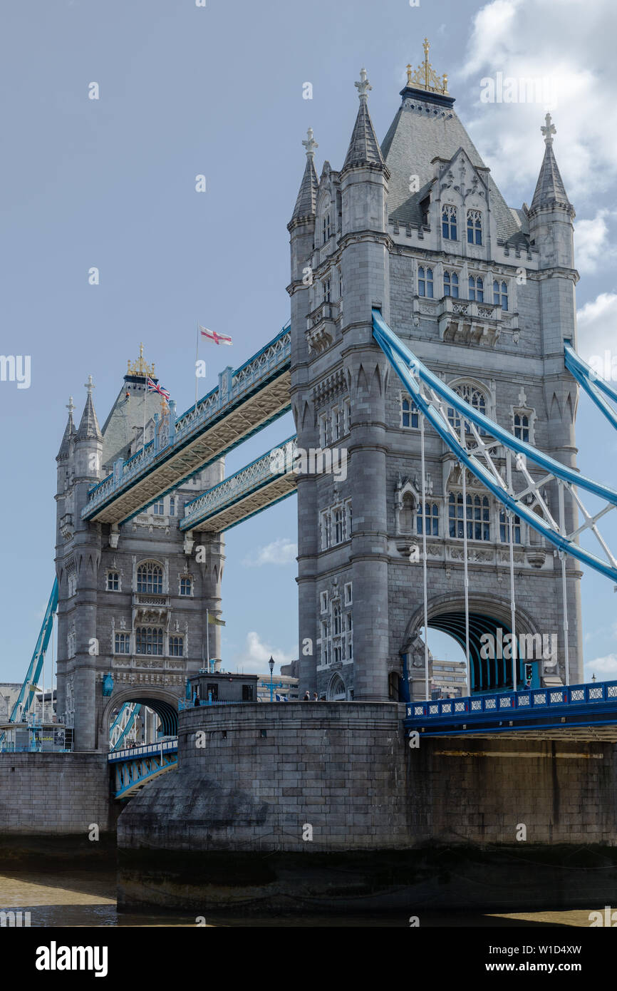 Tower Bridge crosses the River Thames close to the Tower of London and ...