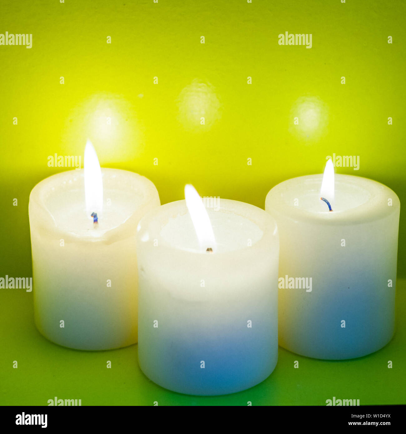 Colorful scented candles on a dark green background Stock Photo - Alamy