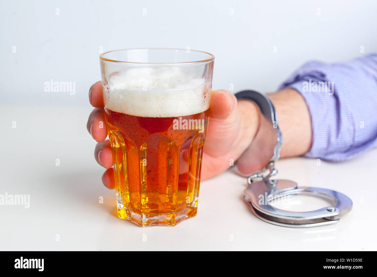 Glass of beer with handcuffs as symbol for alcohol abuse Stock Photo ...