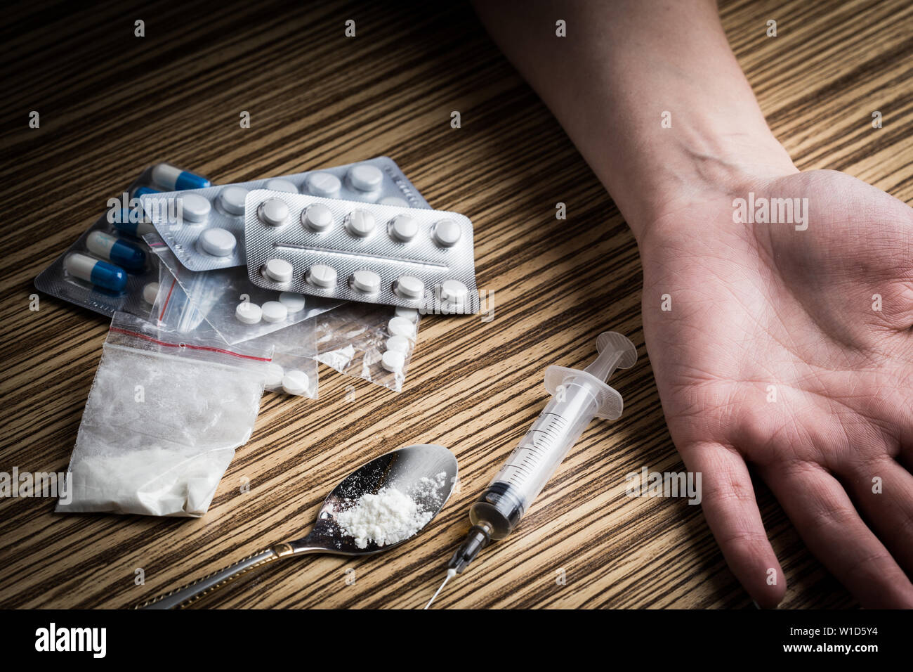 Drug Addict hand with syringe on the floor Stock Photo - Alamy