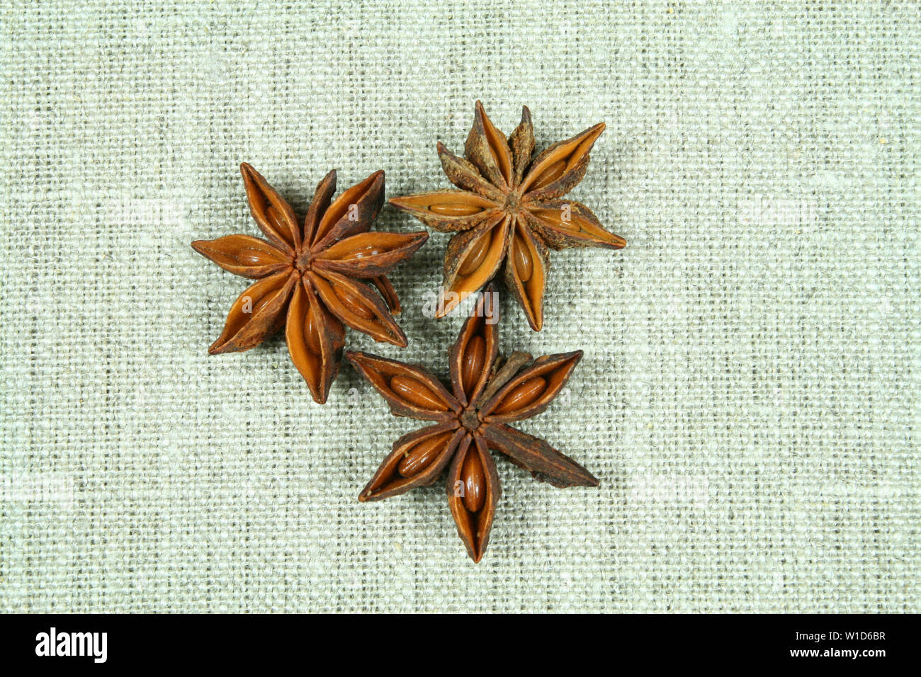 Three anise stars on flax background Stock Photo - Alamy