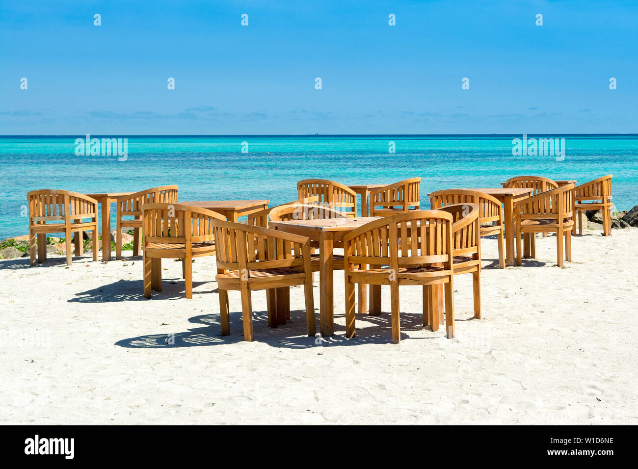 Wooden tables and chairs of tropical restaurant on the sand Stock Photo ...