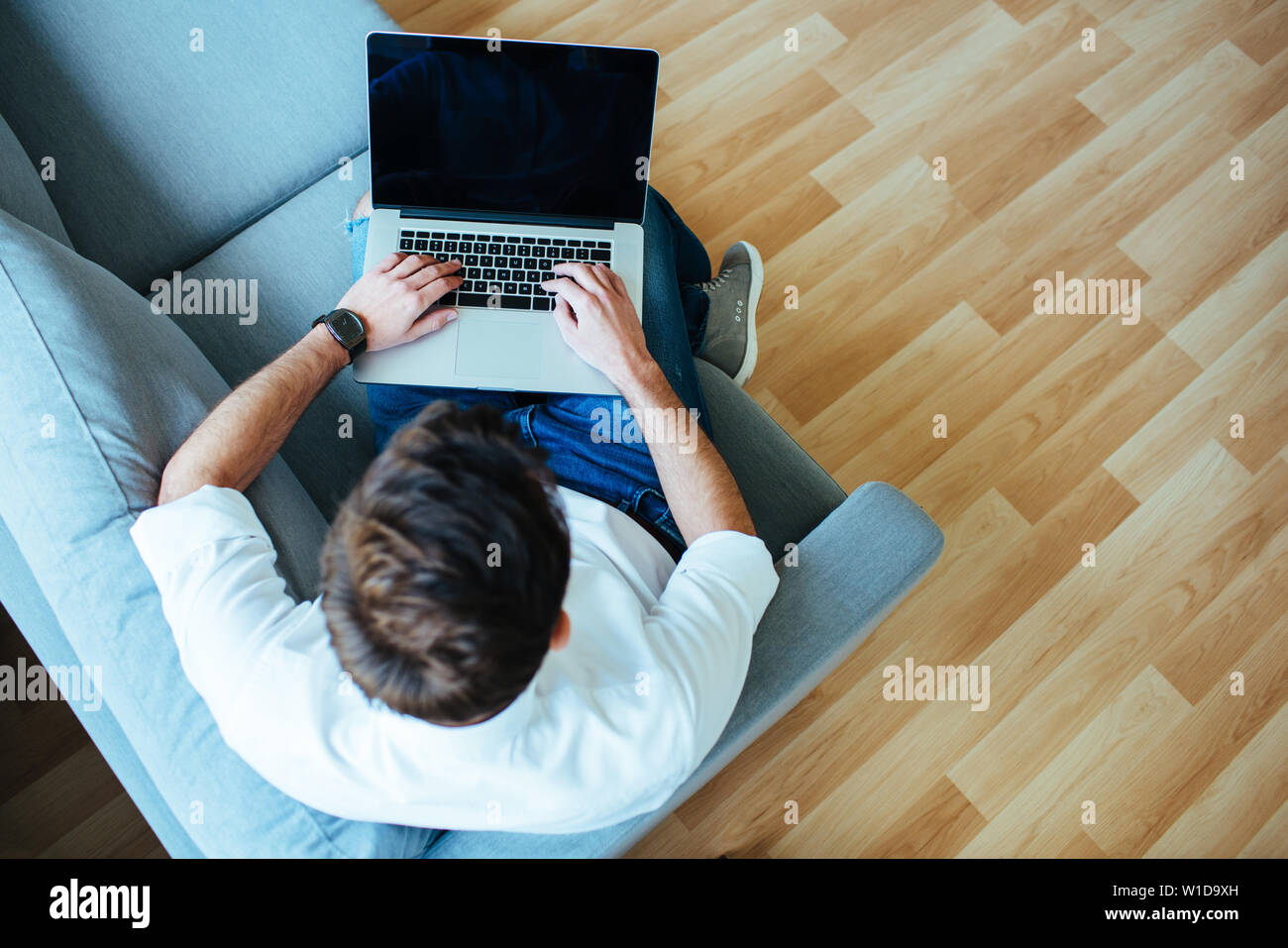 Overhead picture of man using laptop sitting relaxed on sofa Stock ...