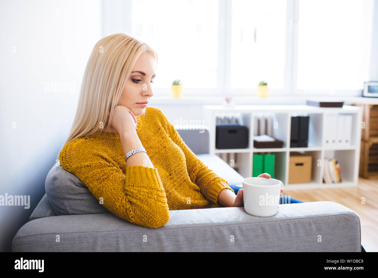 Woman sad alone sofa hi-res stock photography and images - Alamy