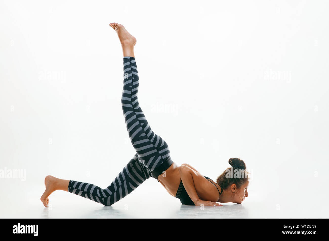 Sporty young woman doing yoga practice isolated on white studio ...