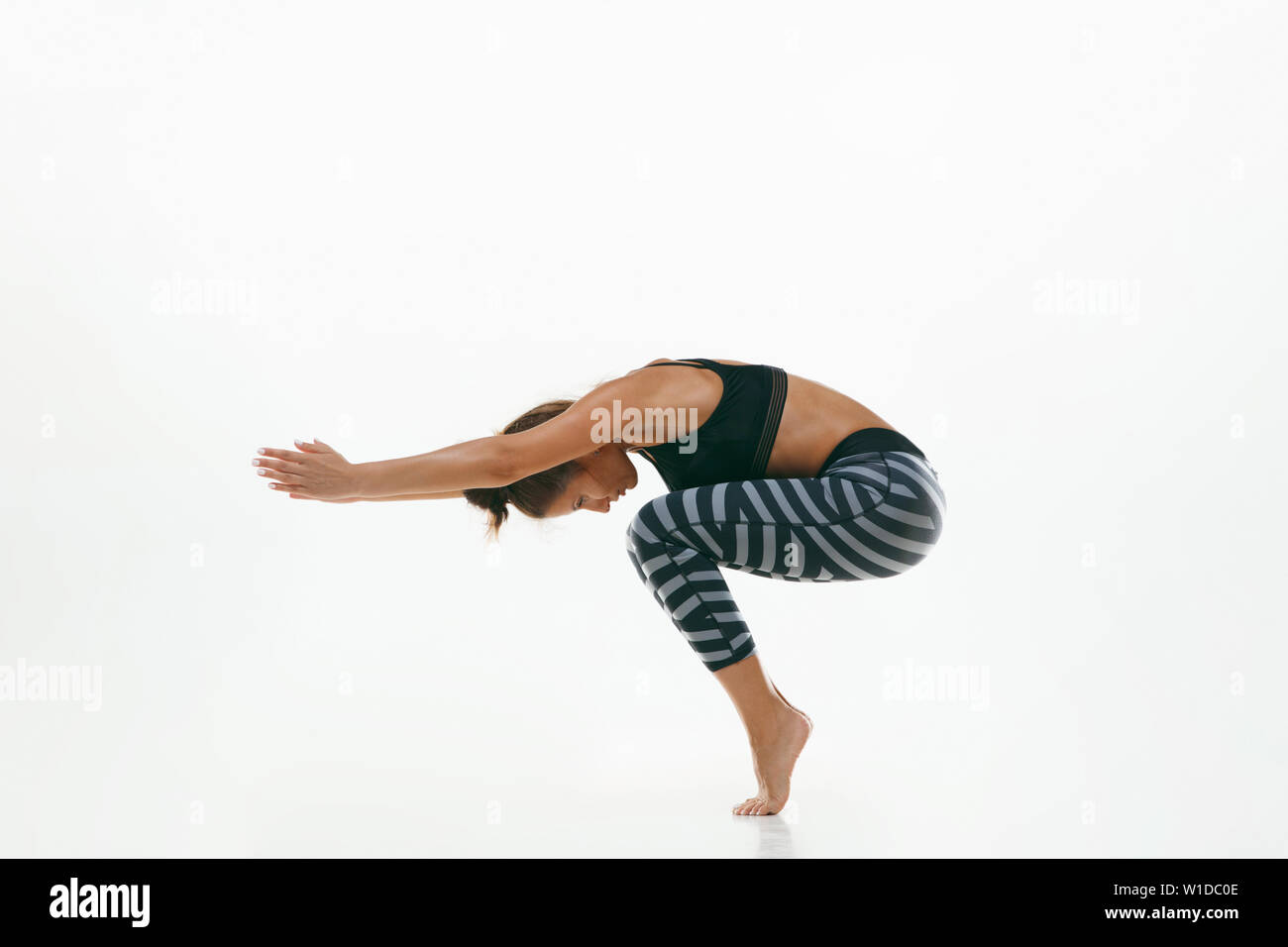 Sporty young woman doing yoga practice isolated on white studio ...