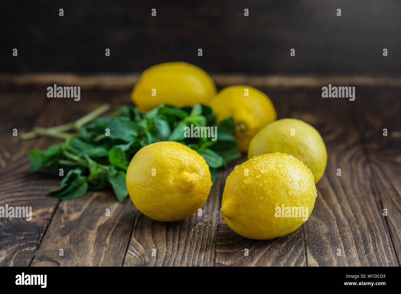 Lemons and mint leaves on wooden background, summer lemonade ...