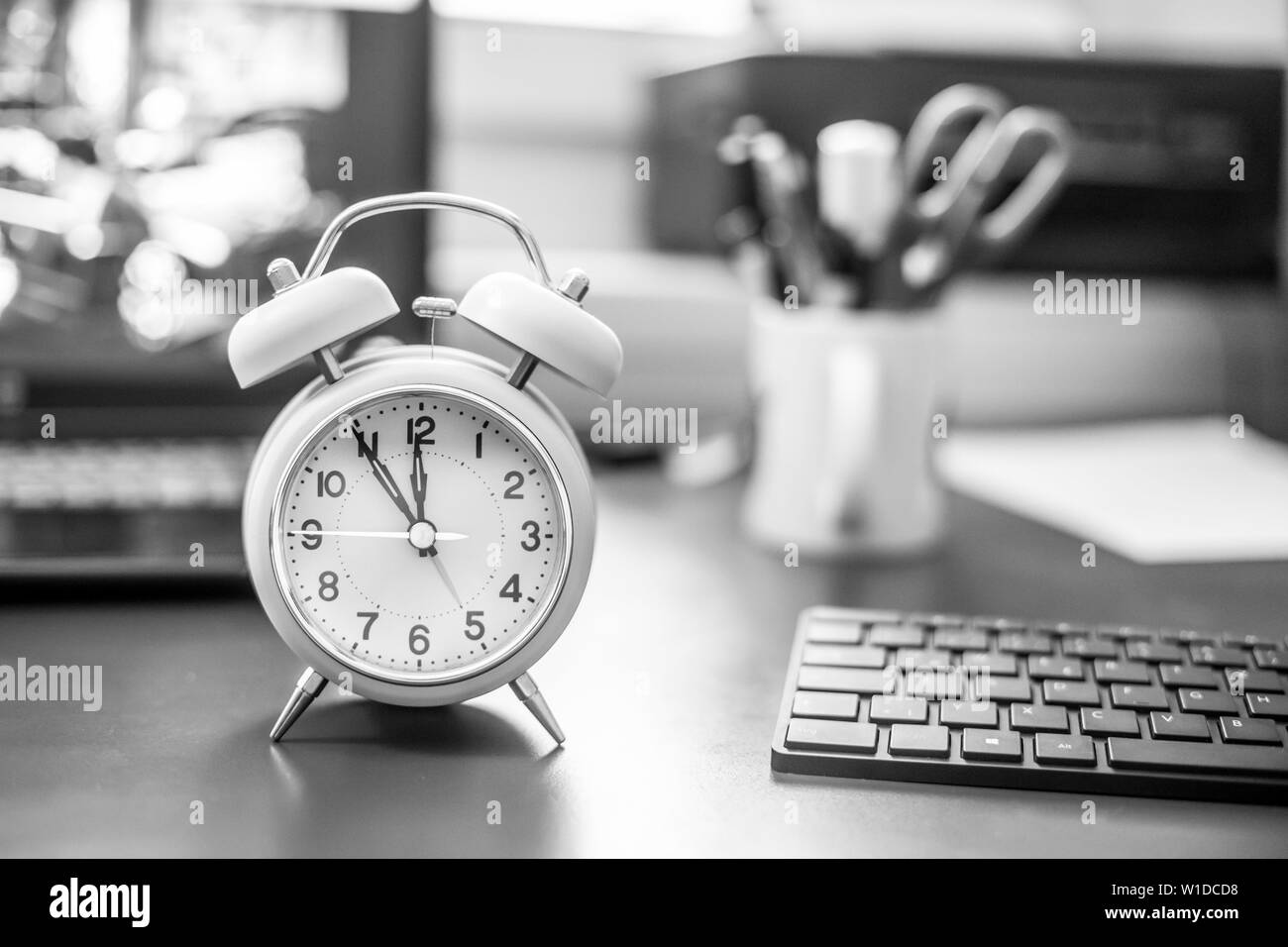 Alarm clock on the desk, office stuff in the blurry background ...