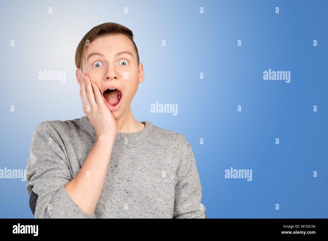 Portrait of young man with shocked facial expression Stock Photo - Alamy