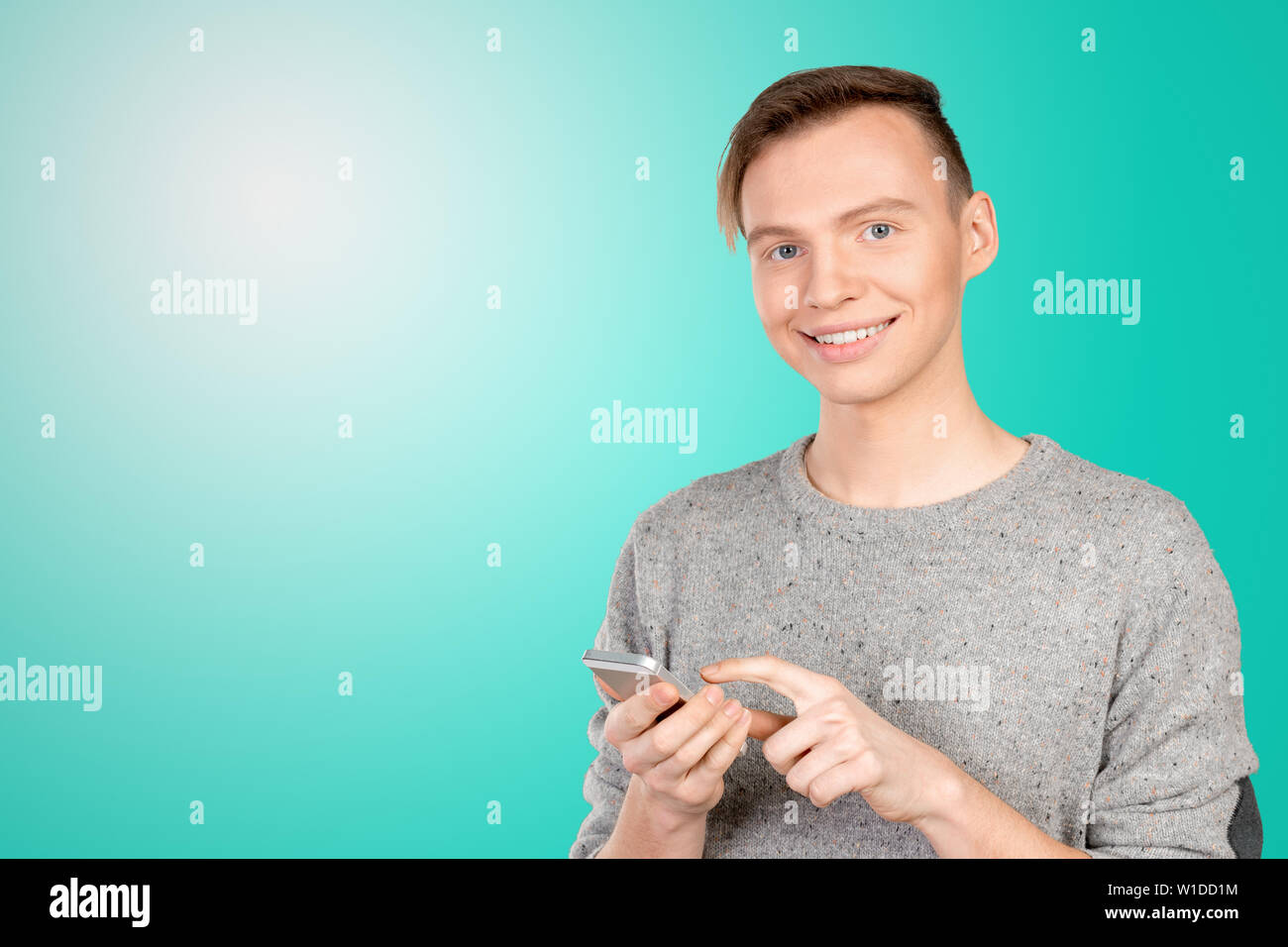 Young man typing text message on his cellphone Stock Photo - Alamy