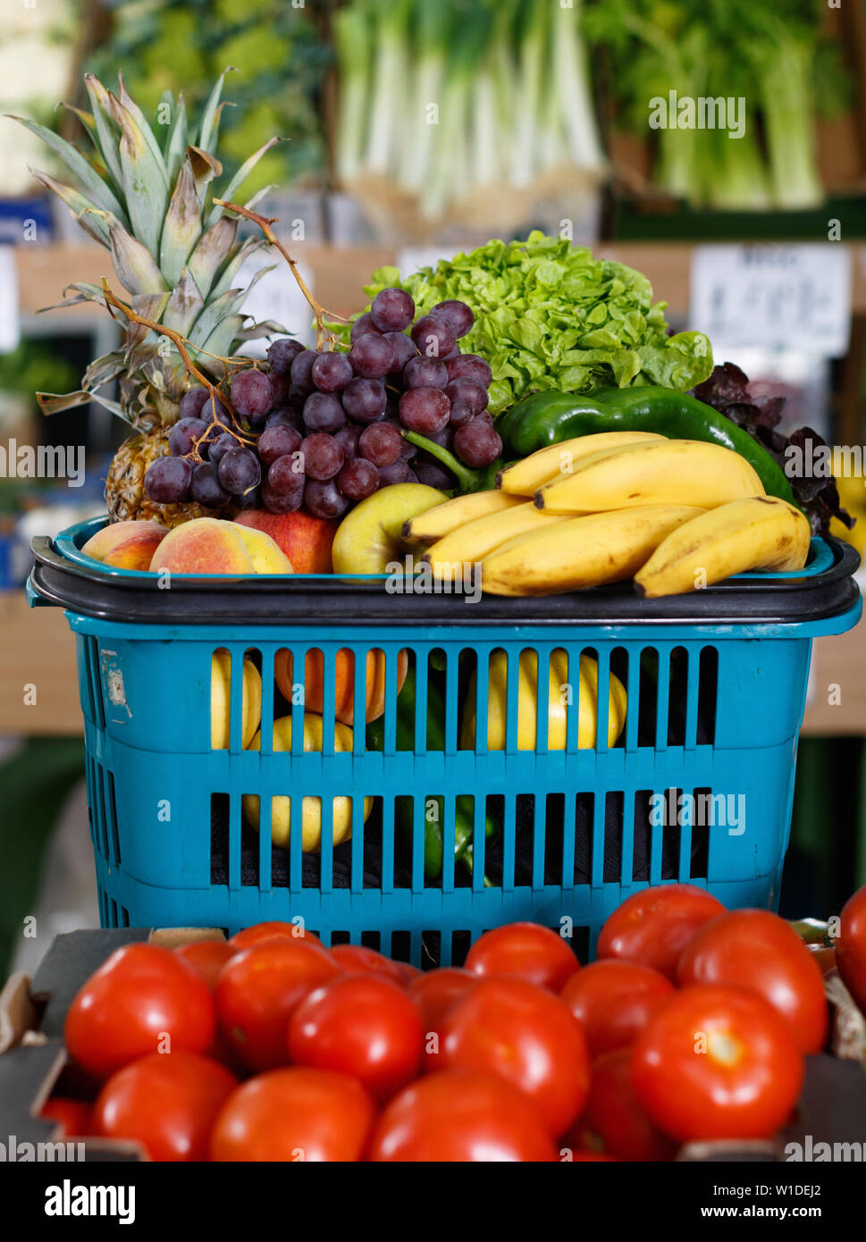 Shopping basket filled with fresh vegetables and fruits on background ...