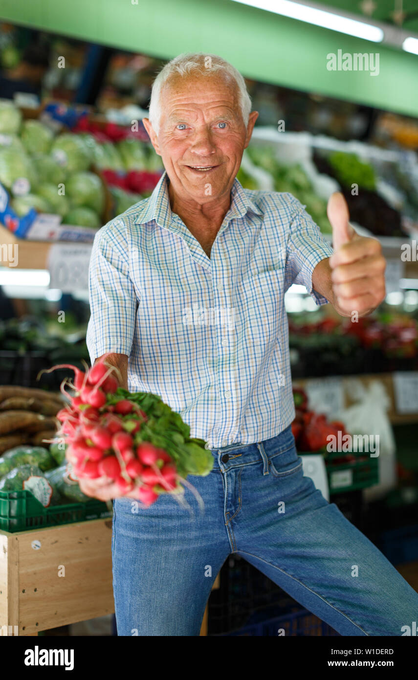 Happy older male purchaser enjoying shopping at local farmer market ...