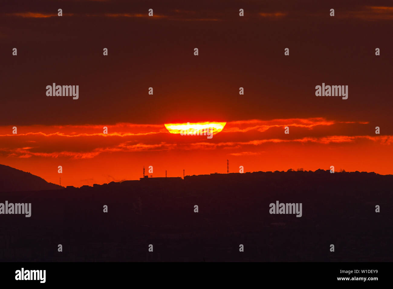 Red sun at sunset under the clouds above the horizon. Epic dramatic ...