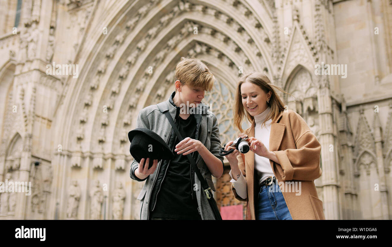 Two stylish friend standing at the street and look for something using ...