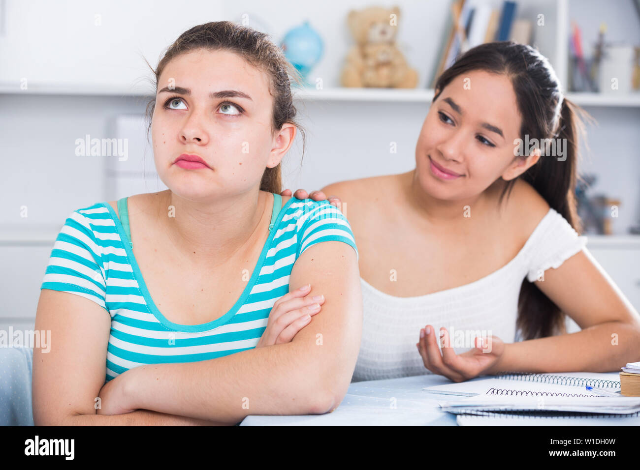 Teen girl trying to calm her female friend and apologize after dispute ...