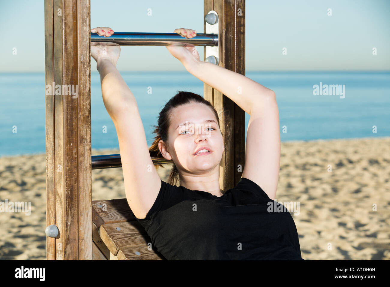 Girl 20-30 years old is doing sit ups on the beach Stock Photo - Alamy