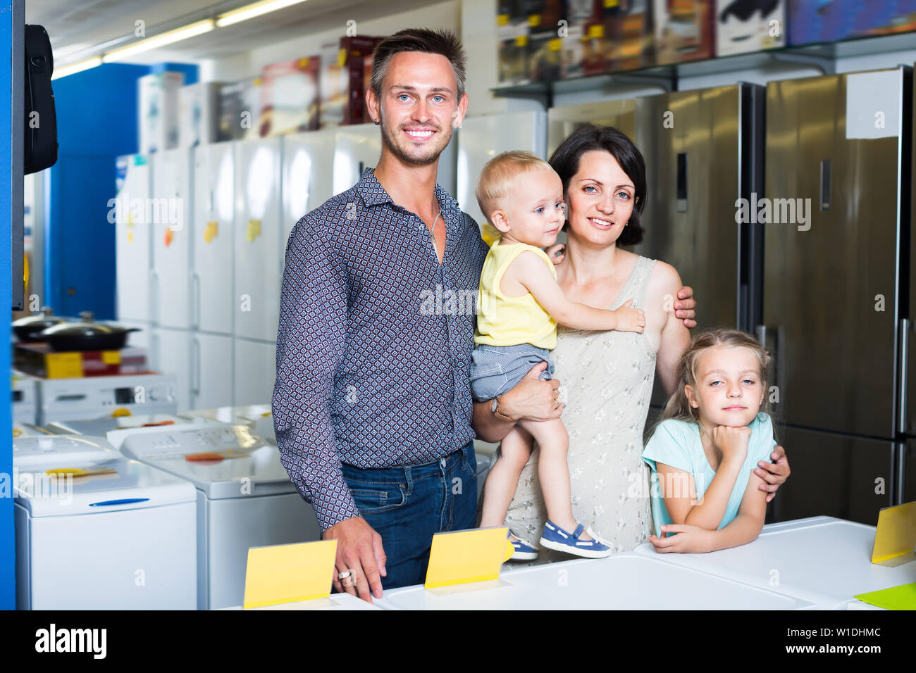 Positive family with two children shopping together in shop of ...
