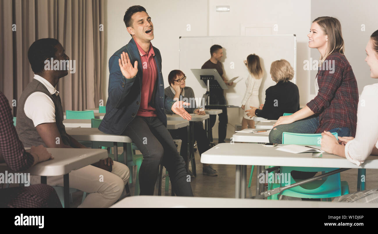 Friendly multinational group of students talking in classroom having ...