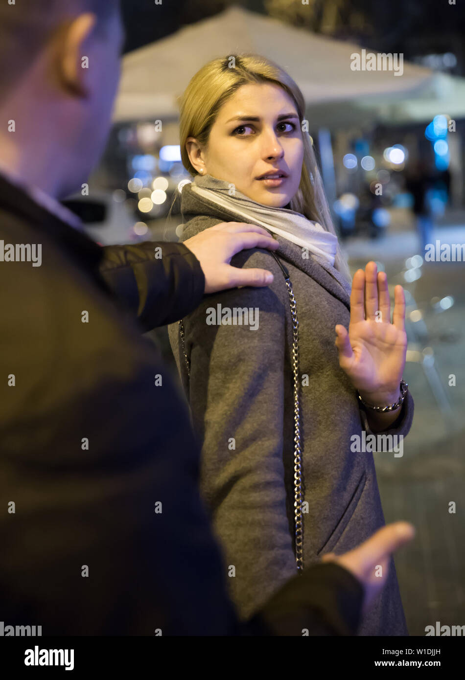 Worried woman and stranger adult man on the street in evening Stock ...