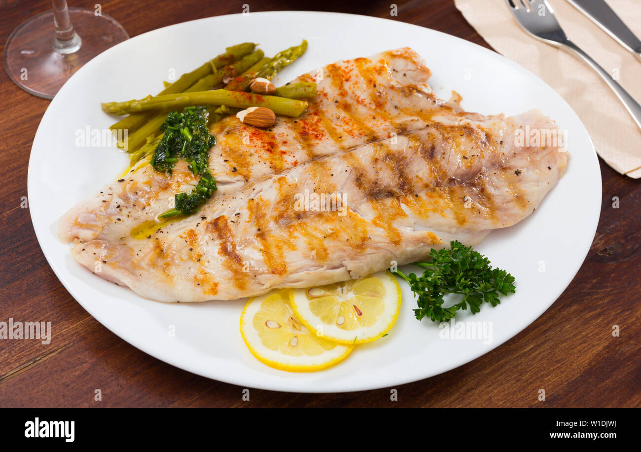 Healthy roasted sea perch fillet served on white plate with pickled ...