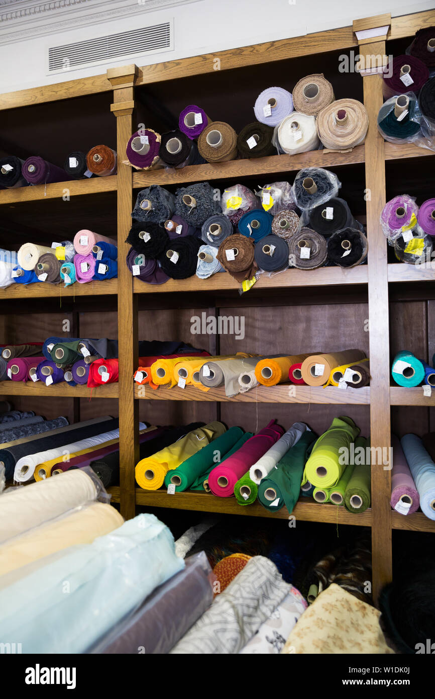 View of cloth rolls of different colors and patterns on shelves in ...