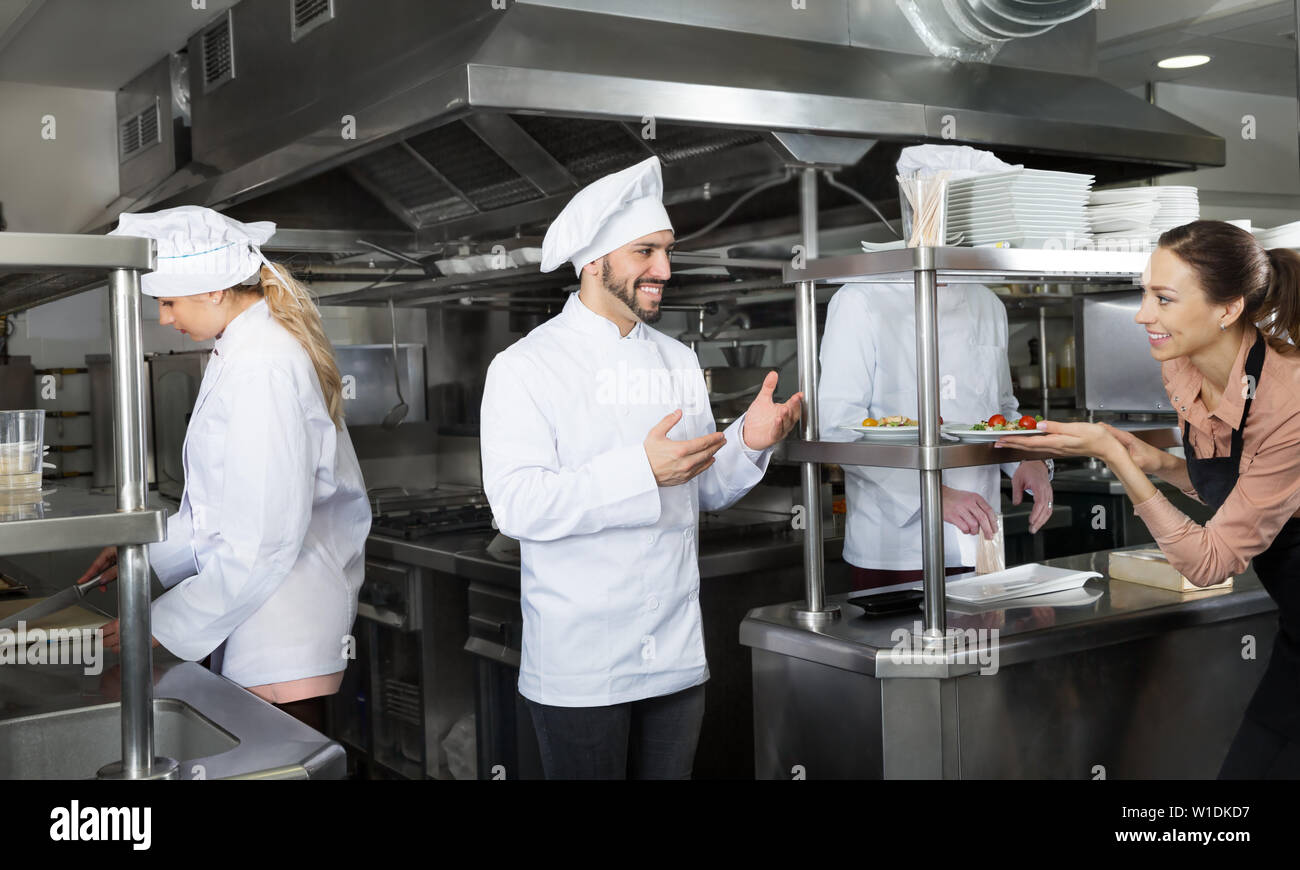 Head chef checking dishes in kitchen of a restaurant before serving ...