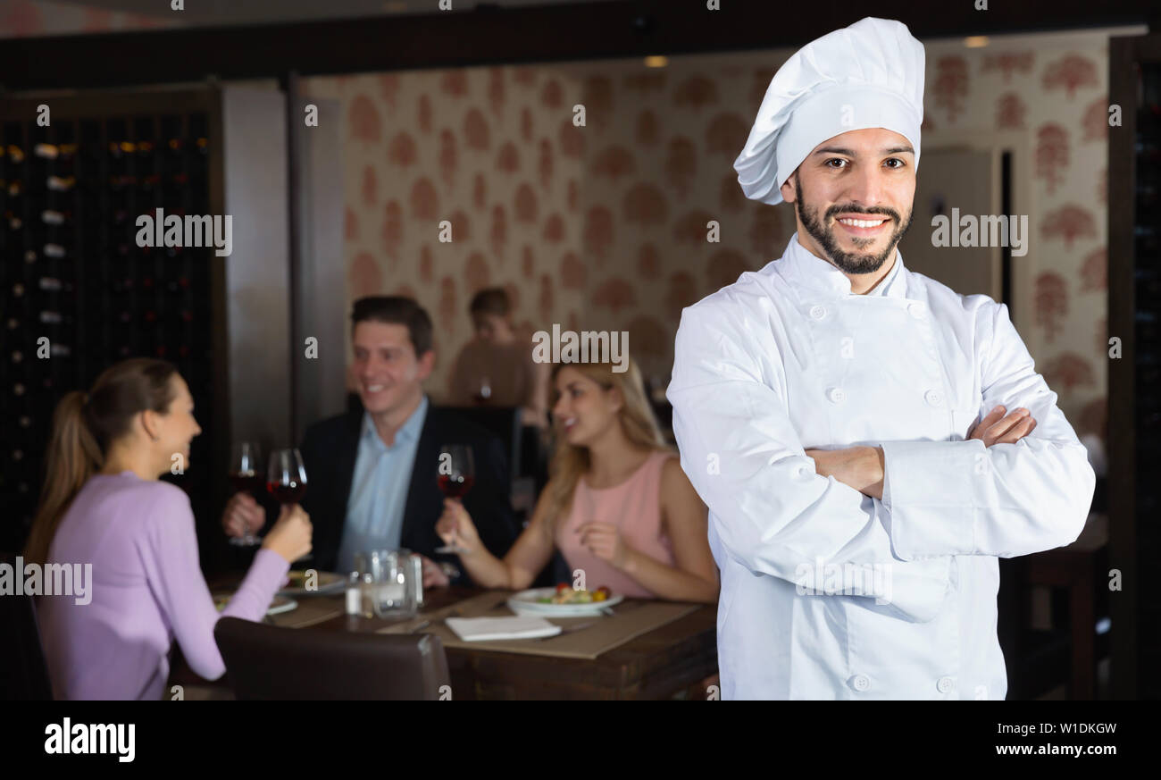 Portrait of cheerful positive handsome professional chef on background ...