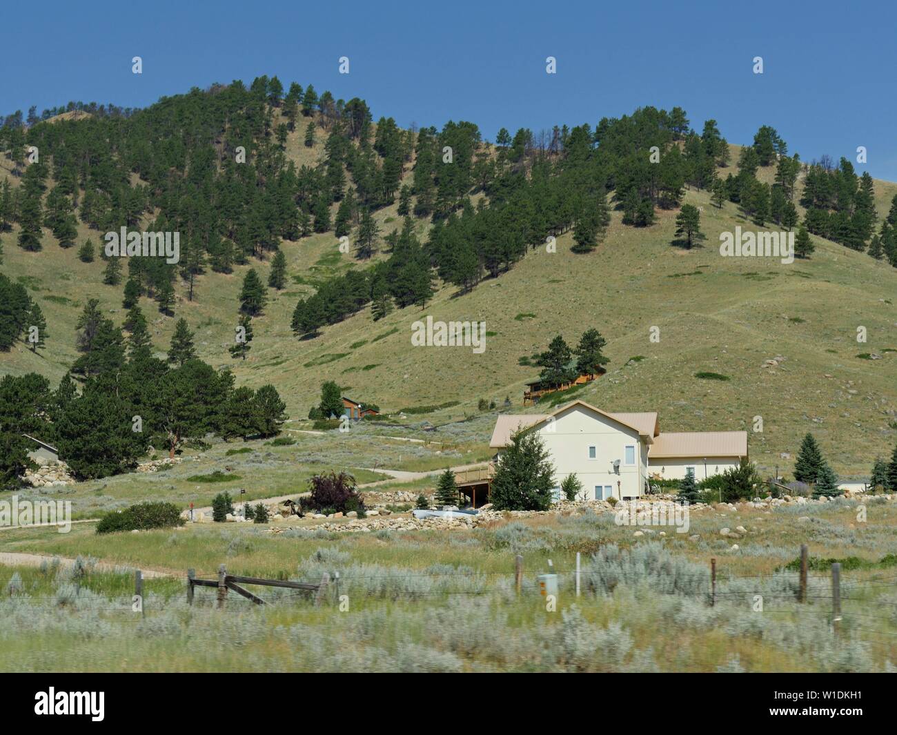 Scenic mountainside view dotted with trees and structures at the foot ...