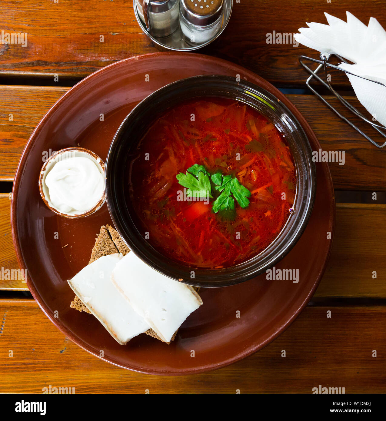 Traditional Ukrainian borsch with sour cream in bowl, bread with bacon ...
