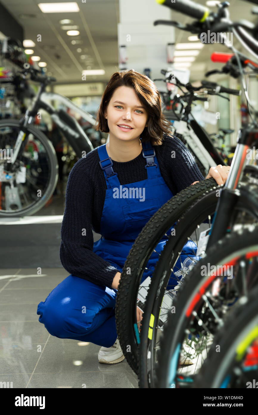 young professional woman holding cycle frame in bicycle shop Stock ...