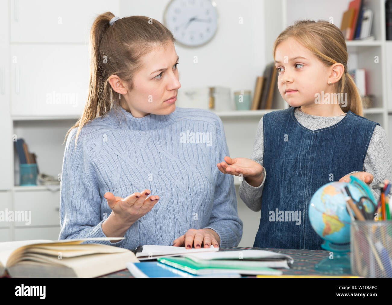 Mother checks school assignments little daughter Stock Photo - Alamy