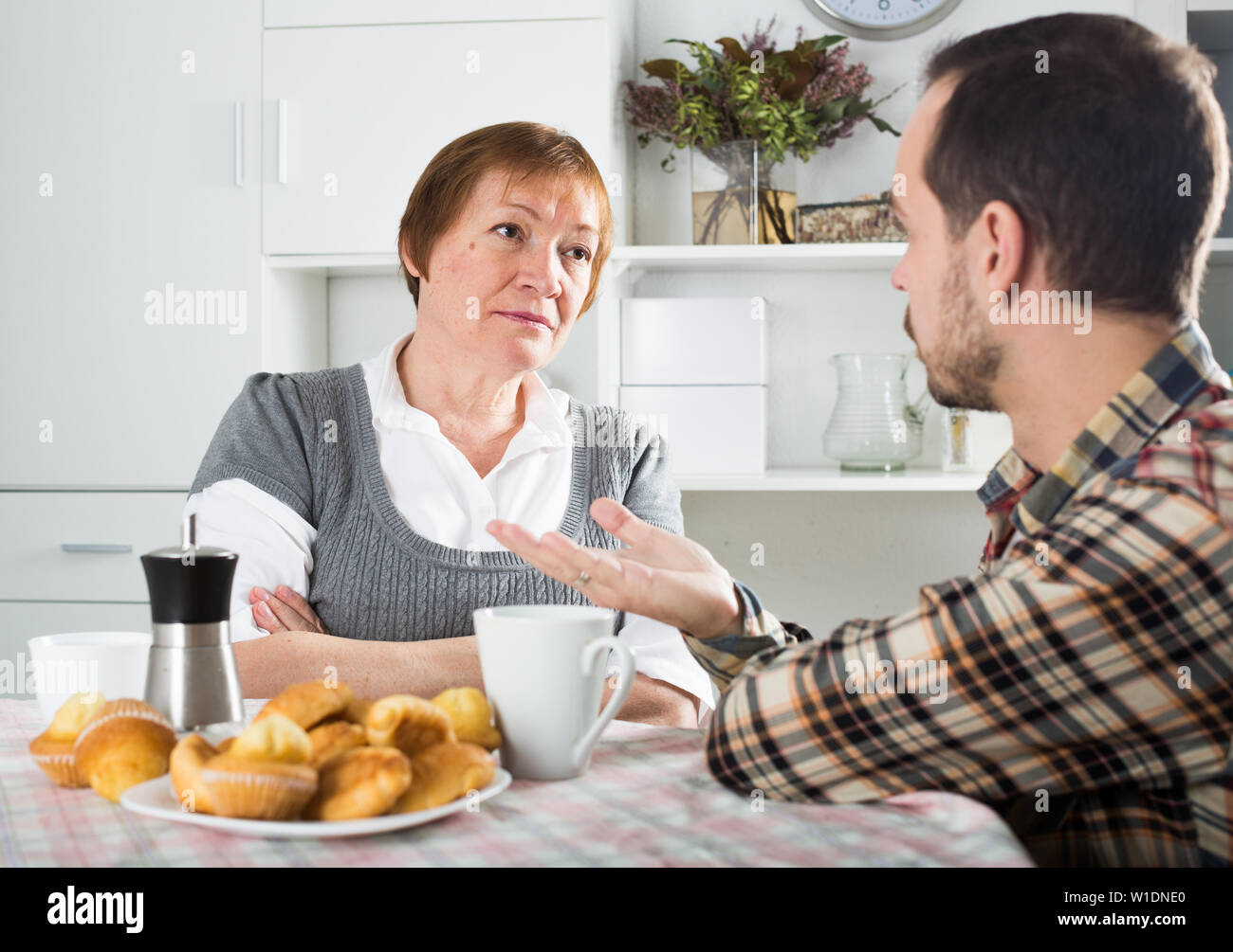 Aged mother arguing with her adult son at home Stock Photo - Alamy