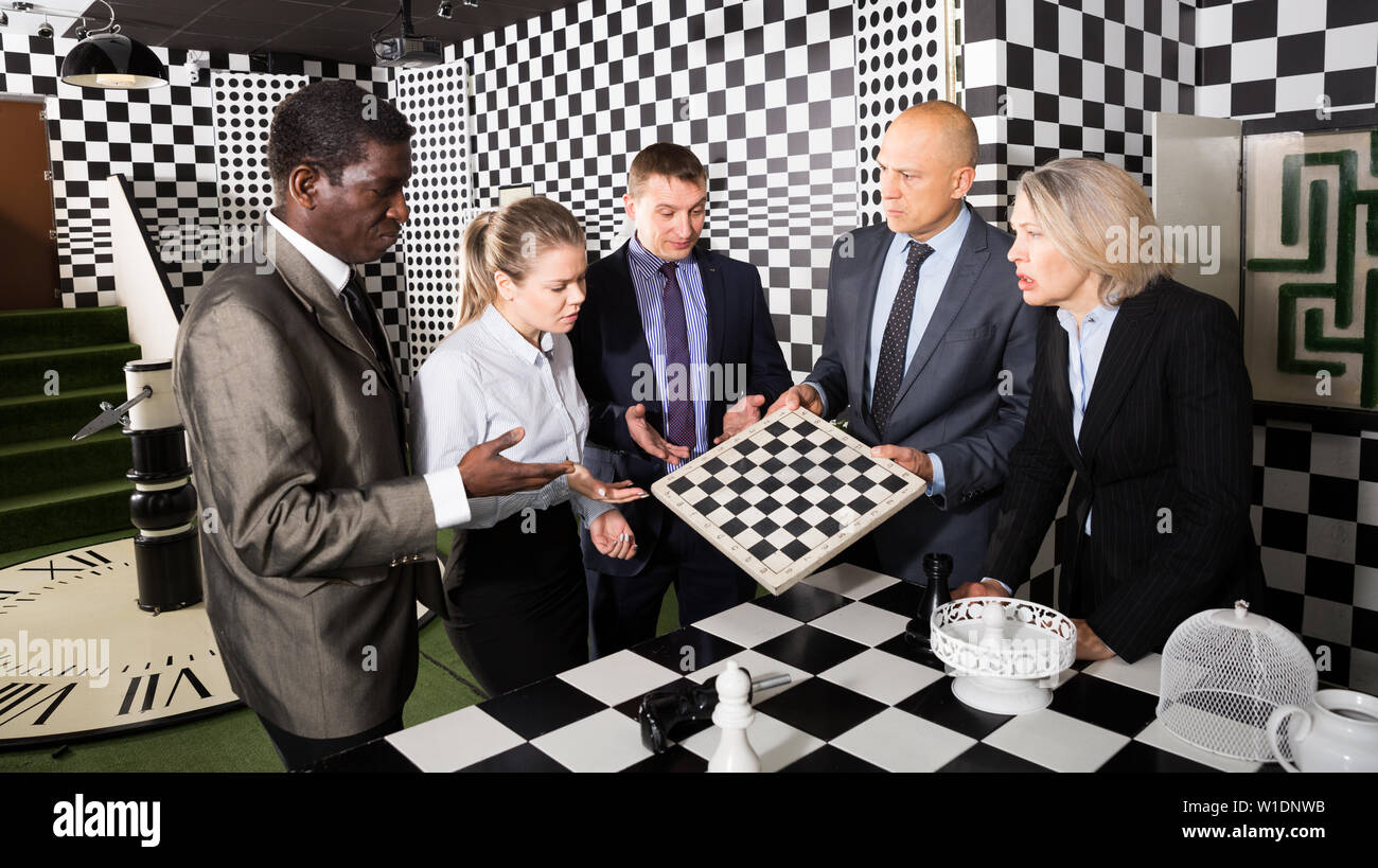 Focused pensive business partners discussing in escape room stylized ...