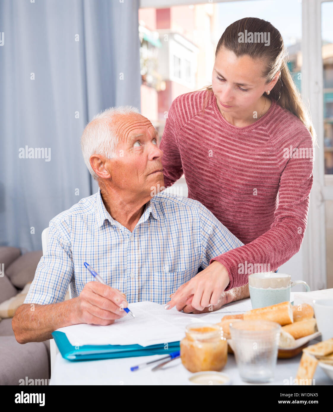 Mature father and adult daughter fill out paperwork Stock Photo - Alamy