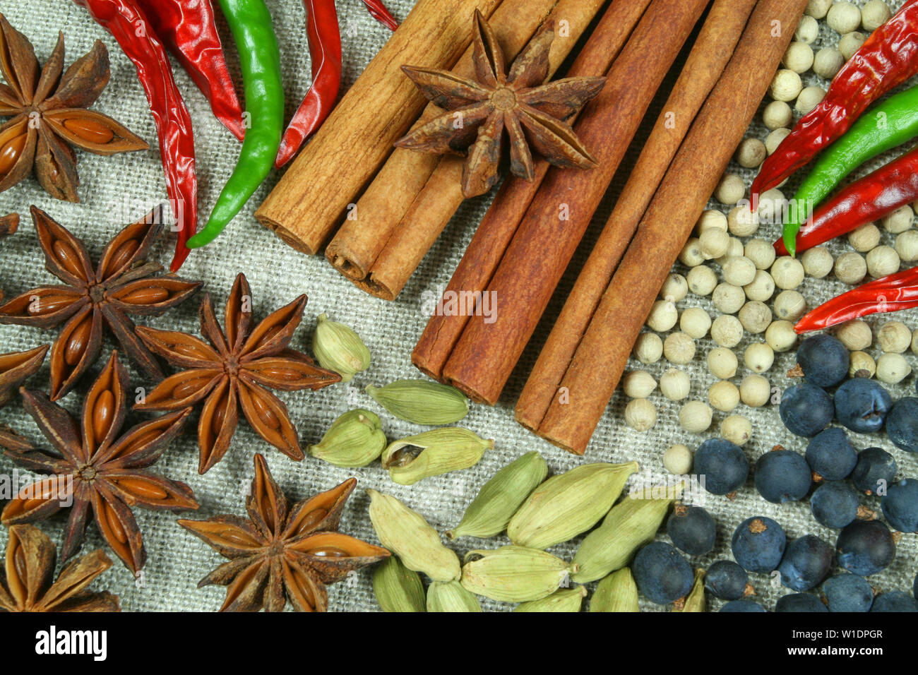 Whole spices collection on flax texture - colorful peppers, anise stars ...