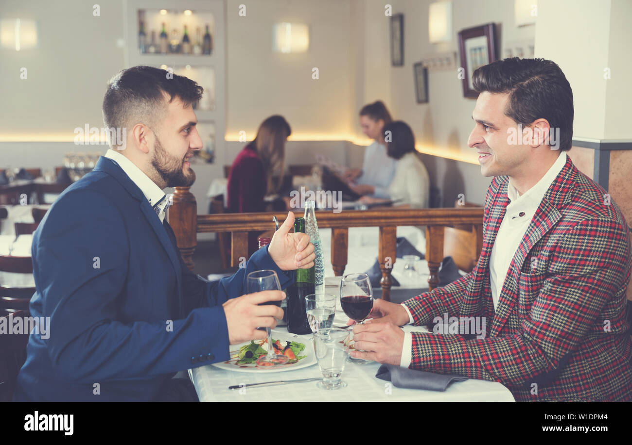 Two men having dinner and drinking red wine at restaurant Stock Photo ...